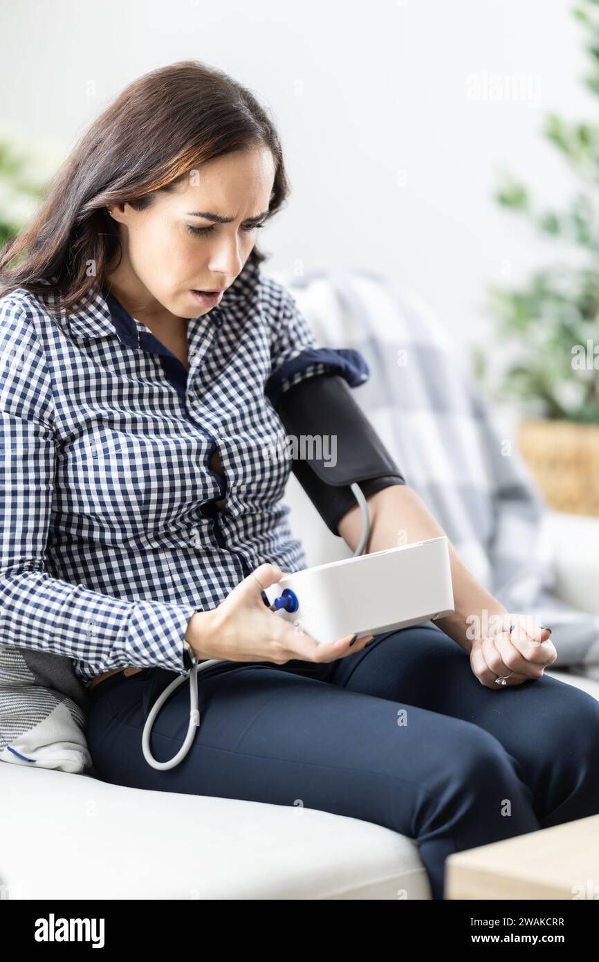 Frightened woman after measuring blood pressure with a measuring device ...