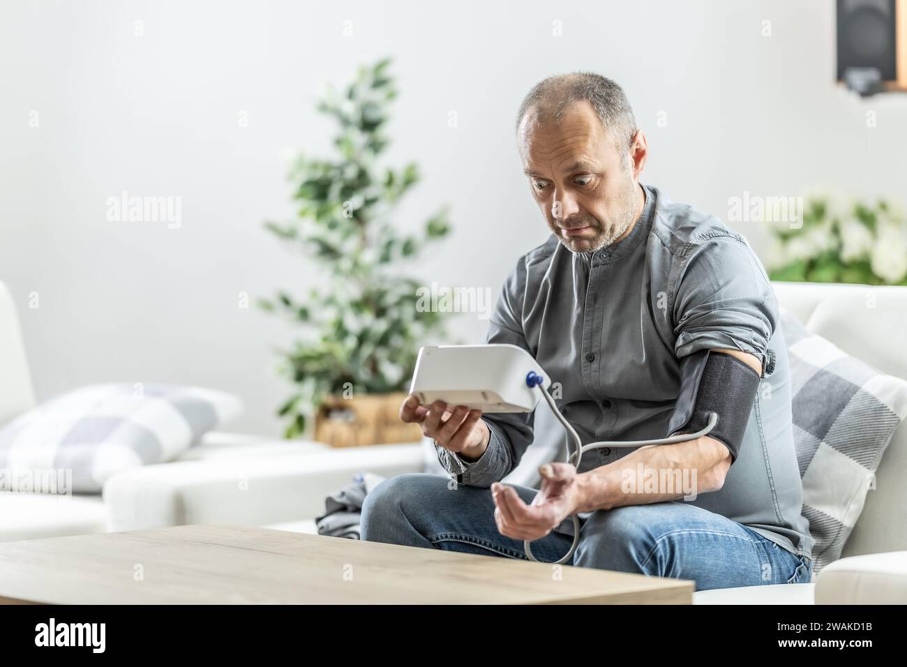 Frightened man after measuring blood pressure with a measuring device ...