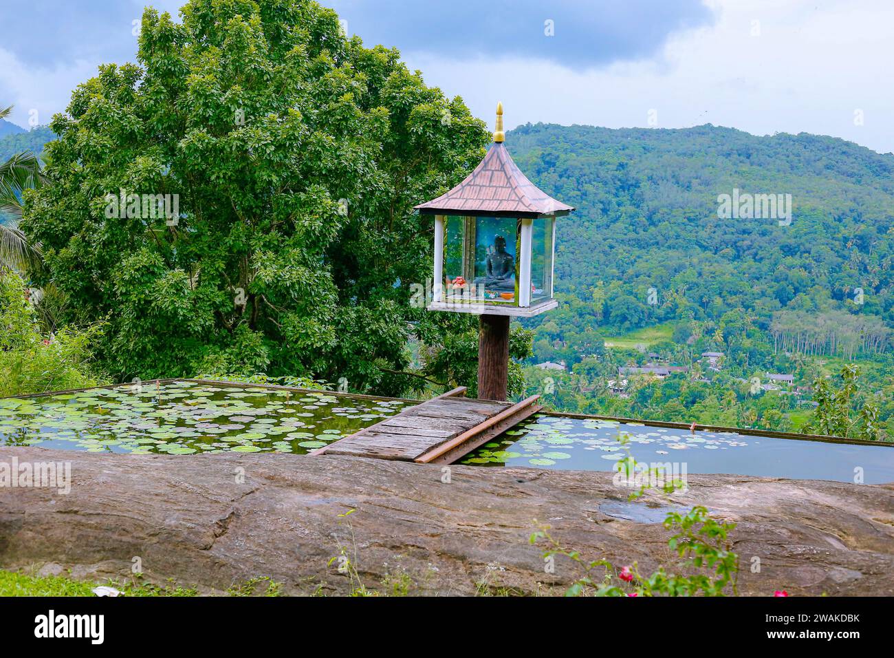 A small Buddha statue set in the middle of a beautiful hilly landscape ...