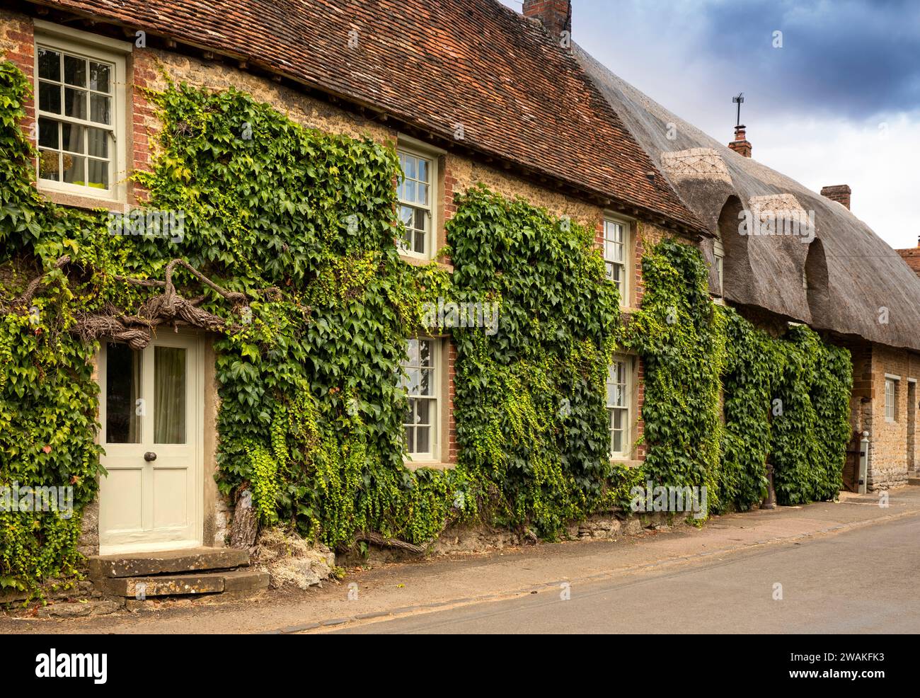 UK, England, Oxfordshire, Hethe, Manor Farm House covered in creeper ...