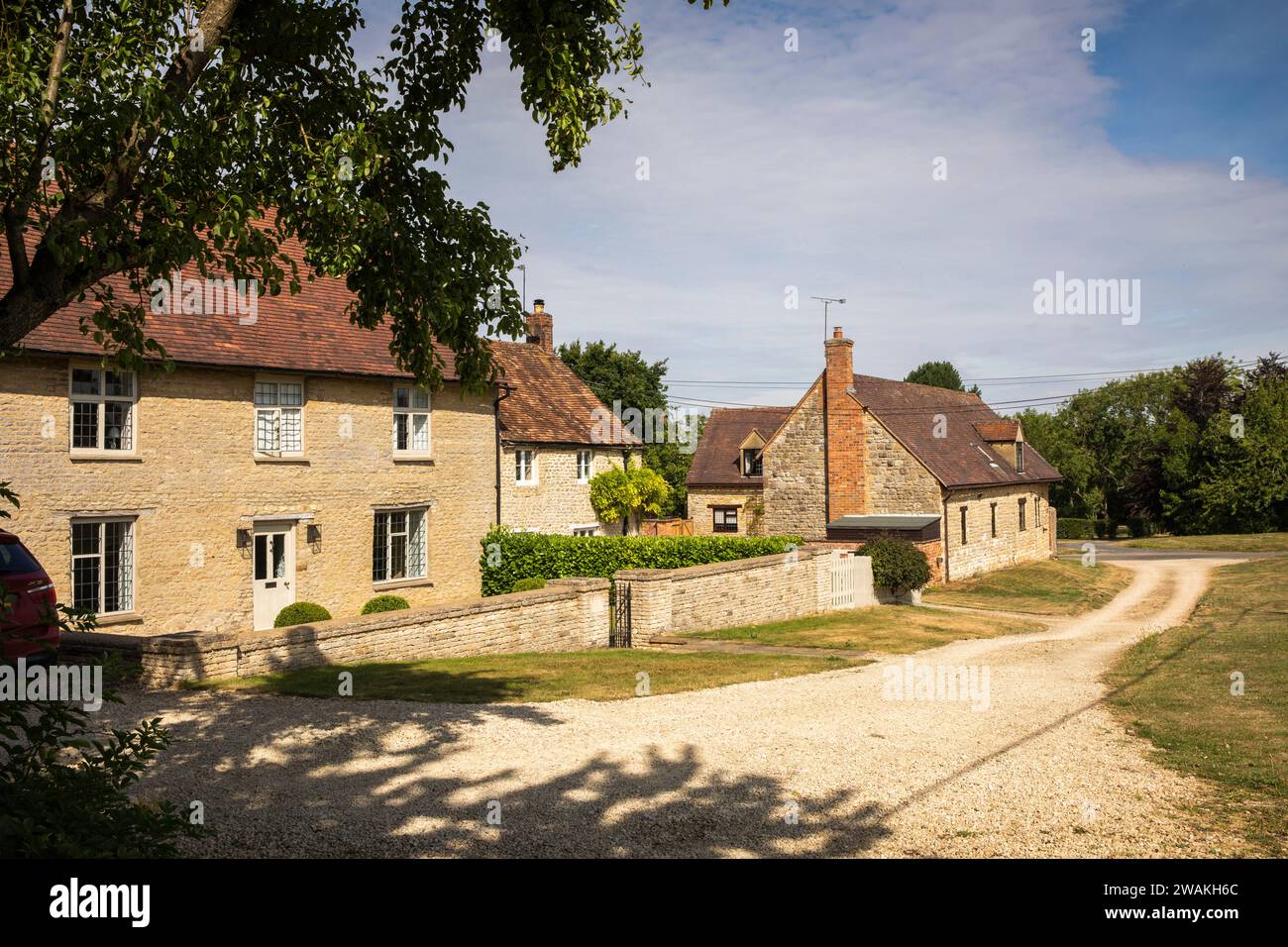 UK, England, Oxfordshire, Fringford, houses at fringe of village green ...