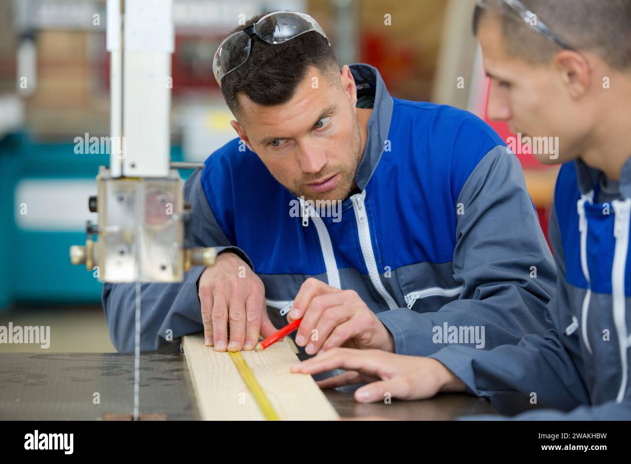 carpenter teaching apprentice how to measure wood Stock Photo - Alamy