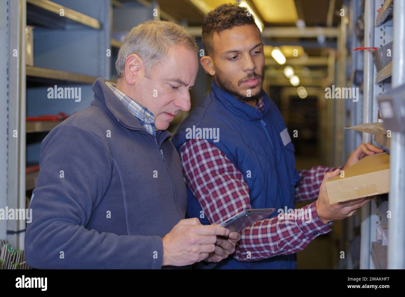 men checking goods in warehouse Stock Photo - Alamy