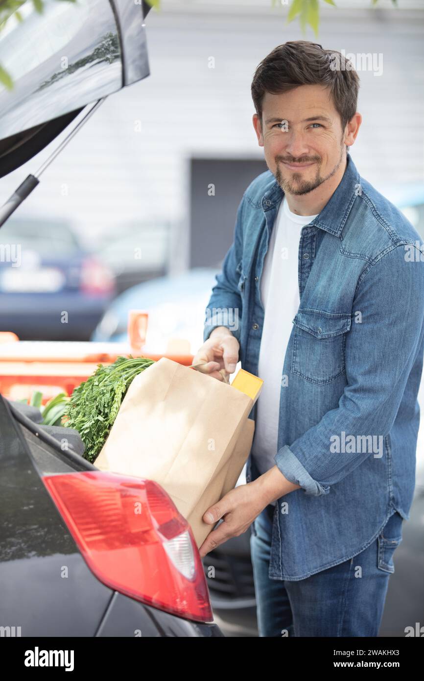 man loadinggroceries into boot of his car Stock Photo - Alamy