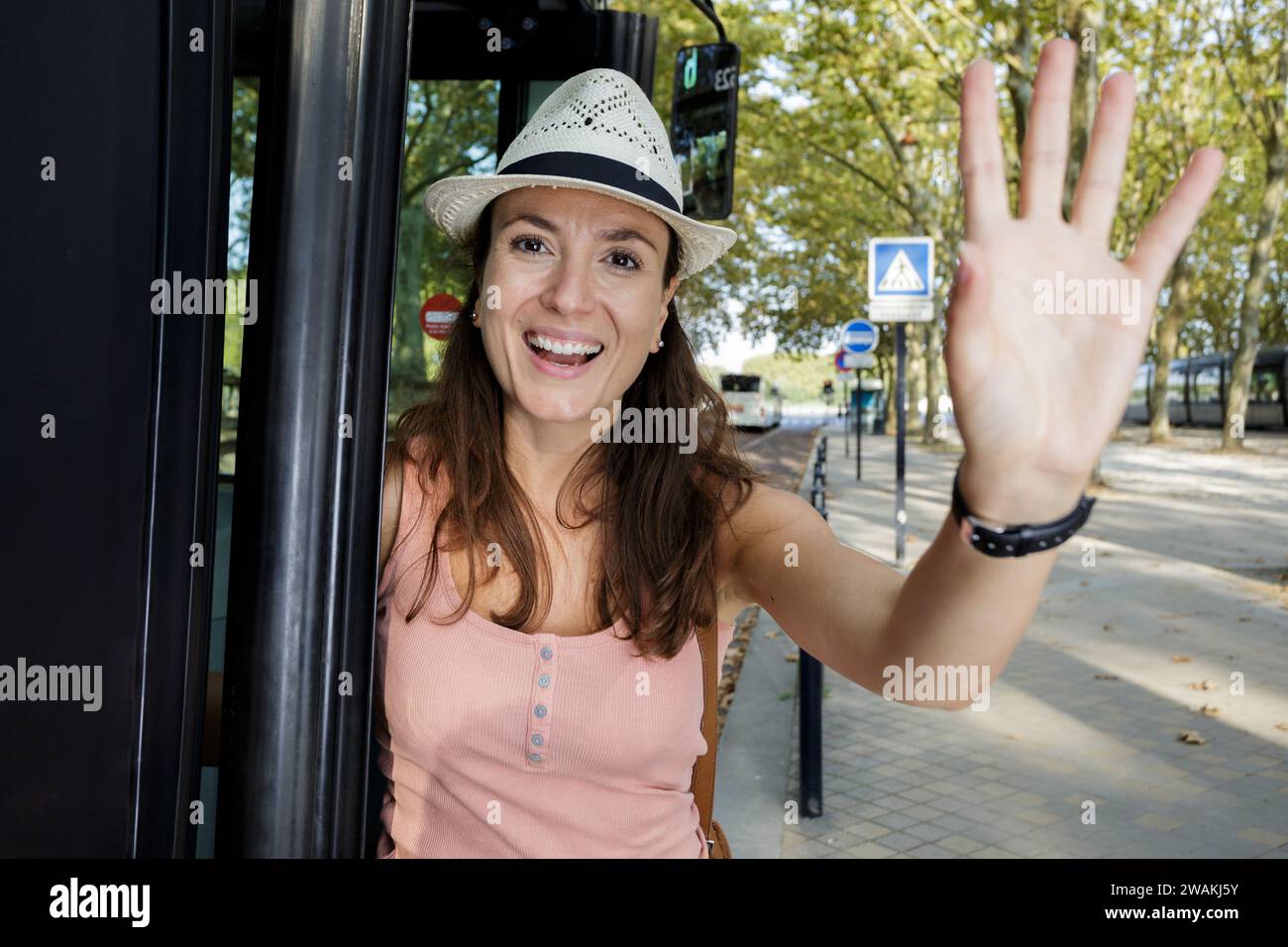 happy female tourist waving from bus Stock Photo - Alamy