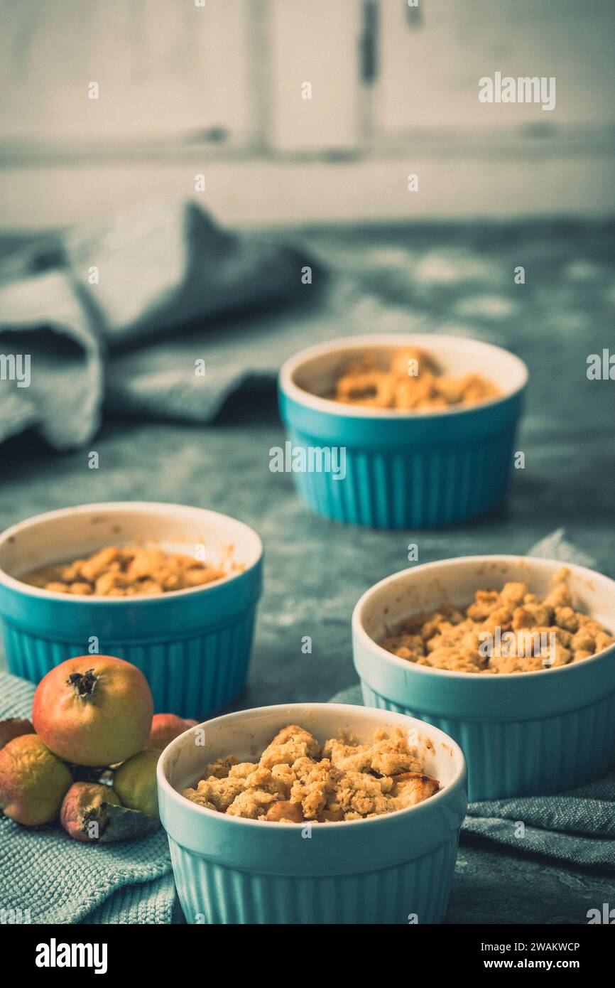 Apple crumble in small blue molds on a rustic gray table, vertical ...