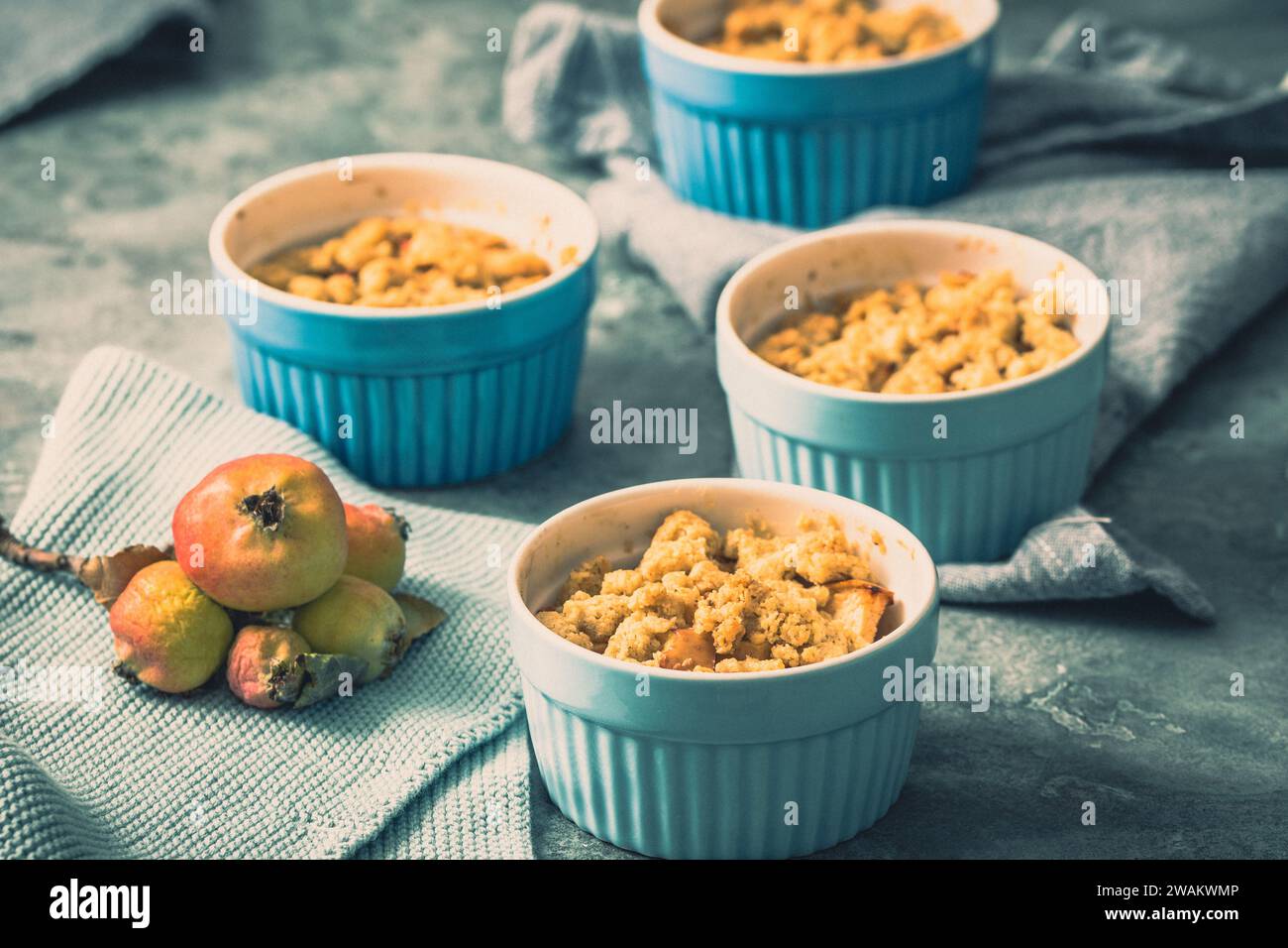 Apple crumble in small blue molds on a rustic gray table Stock Photo ...
