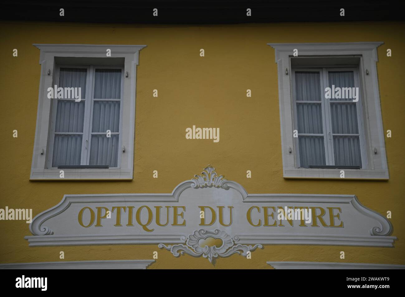 Scenic facade view of a local optics store with an ochre stucco wall ...