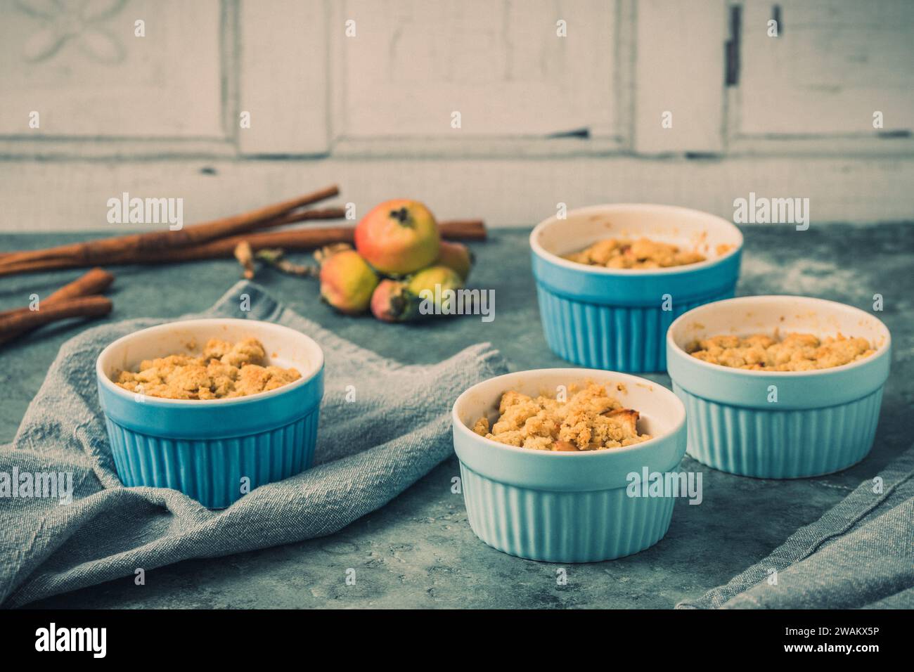 Apple crumble in small blue molds on a rustic gray table Stock Photo ...
