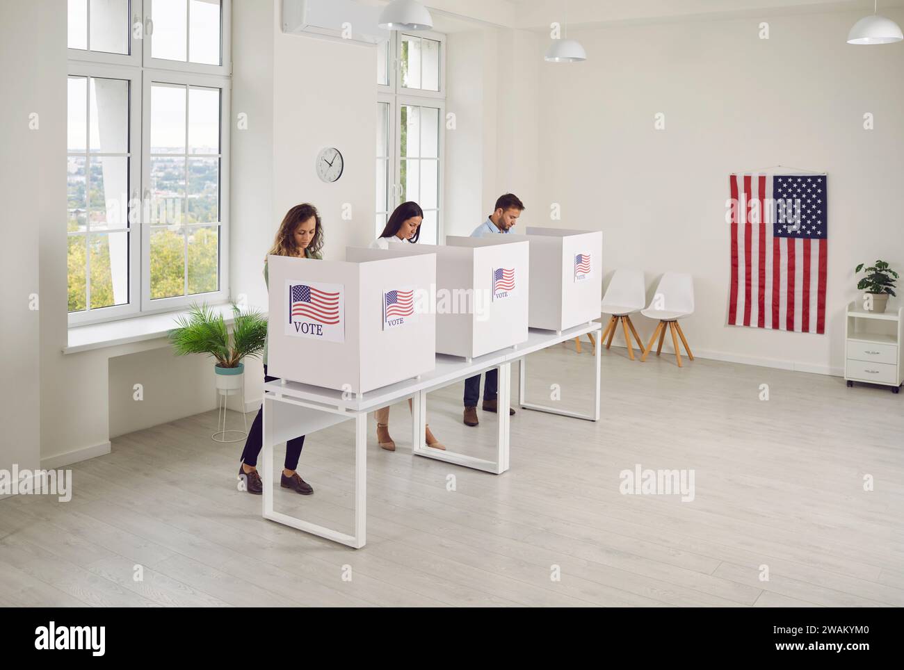 People voting standing in a row in voting booth at polling station at ...
