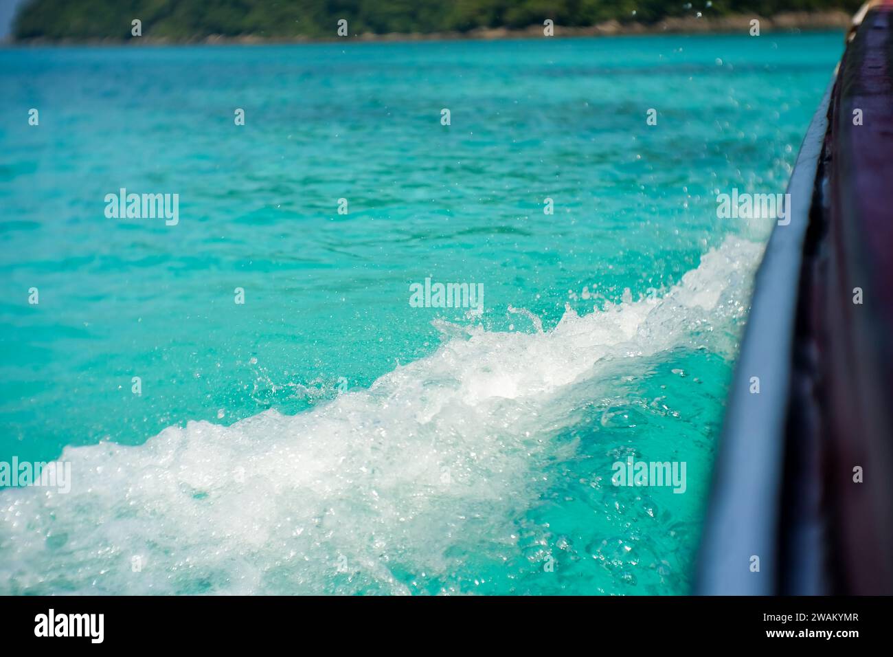 High angle of ship trail forming wave on surface of blue water of ocean ...