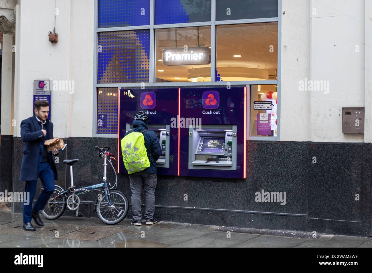 London, UK - December 2, 2023, A man withdraws money from an ATM in ...