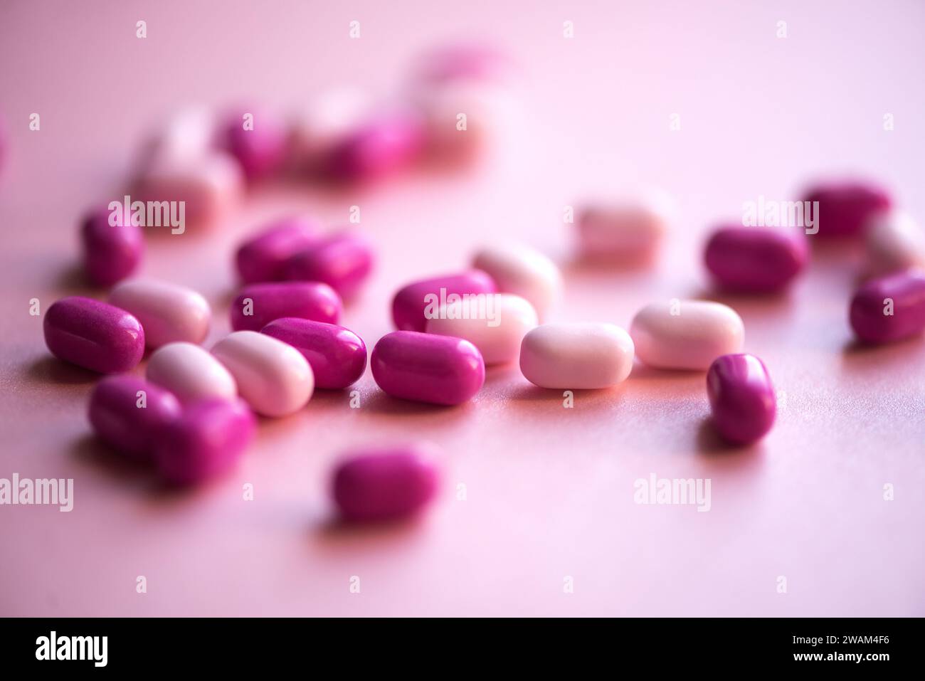 An array of pink pharmaceutical drugs arranged on a table in the shape ...