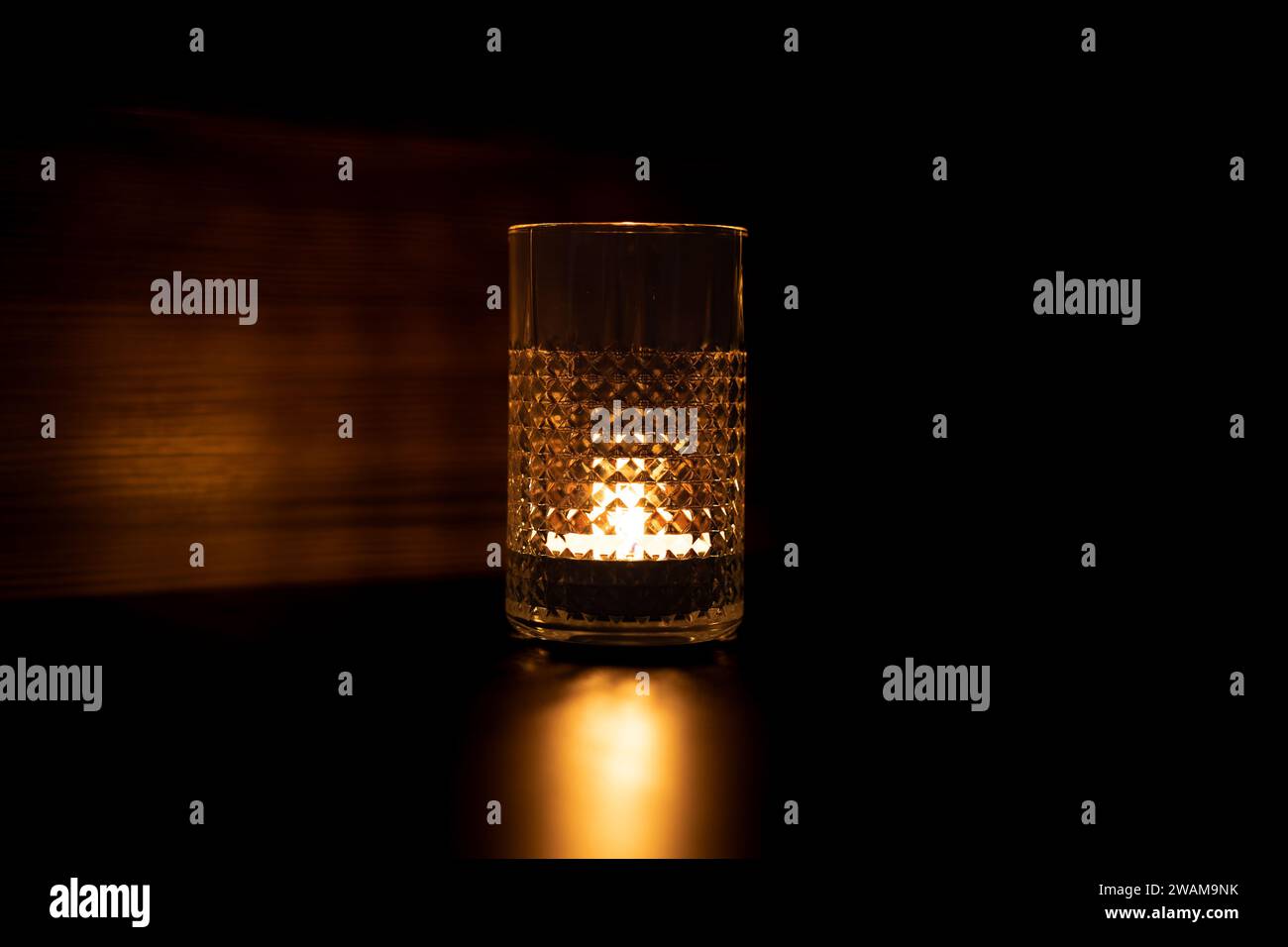 Candle in a glass. Rays of light are refracted through the walls of the ...