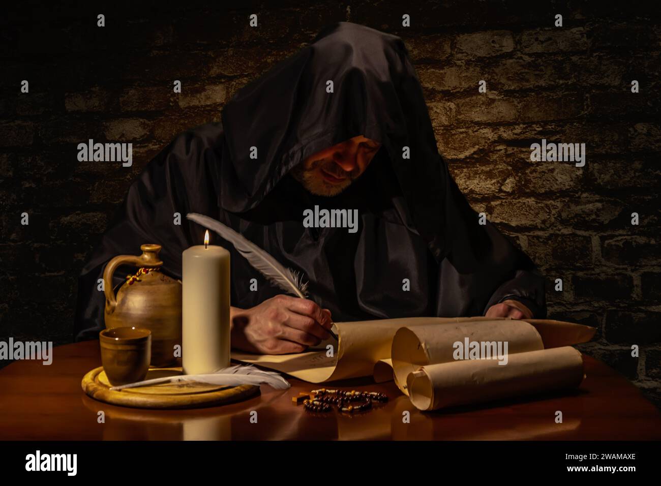 An old monk in his cell writes a message on parchment with a goose ...