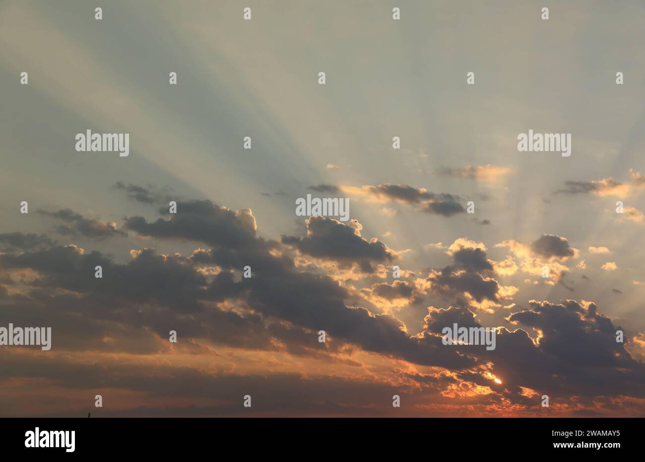 Beautiful sunrise with warm orange sunlight and beams through cloudy ...