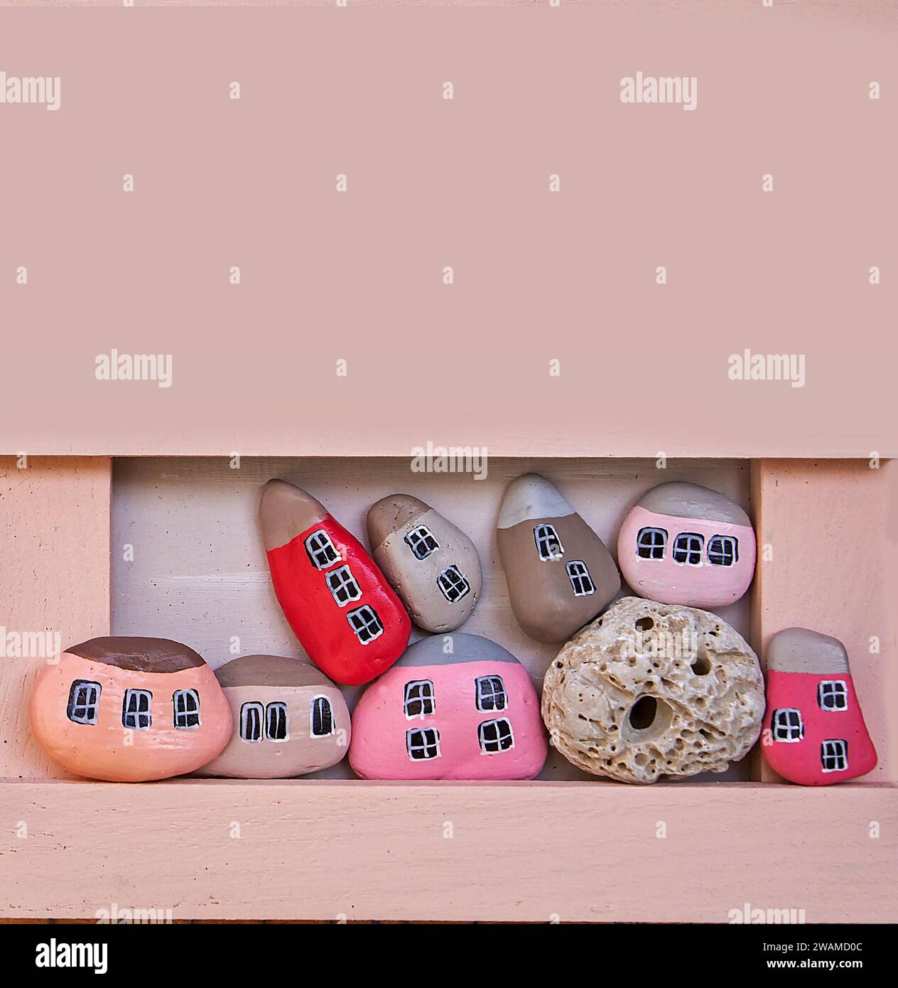 multi-colored houses with windows made of pebbles on a peach background ...
