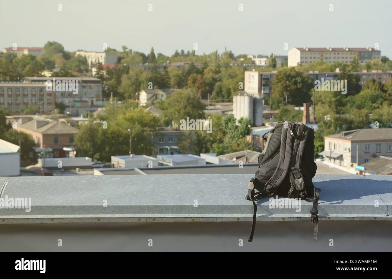 Black backpack lies on metal border of residental multistorey building ...