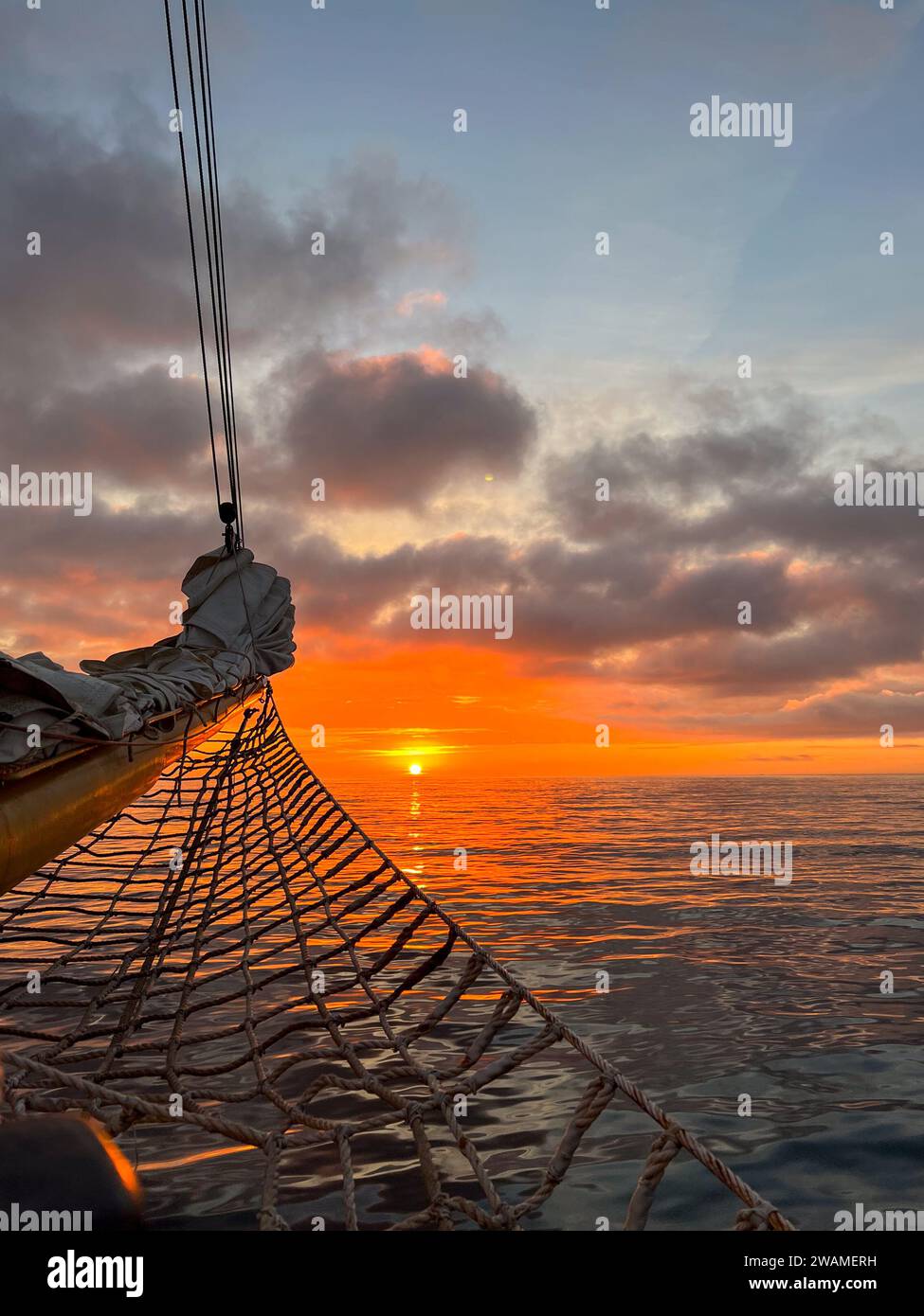 Orange sunrise over the Atlantic Ocean seen from a tall ship bow Stock ...