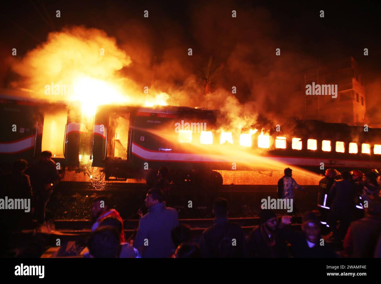 Dhaka. 5th Jan, 2024. Firefighters battle a fire raging on a train in ...