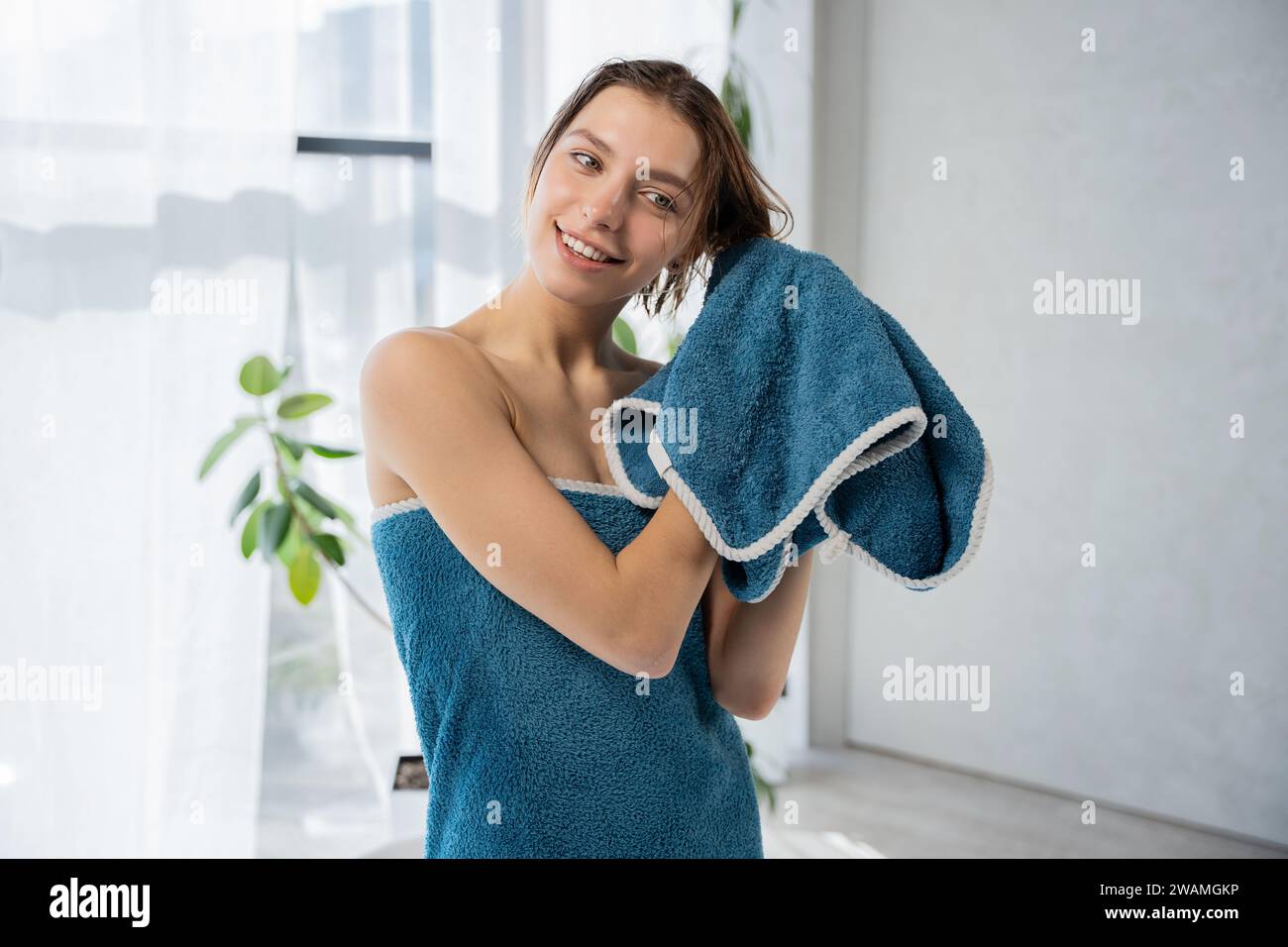 Young female drying wet hair with towel in bathroom Stock Photo - Alamy
