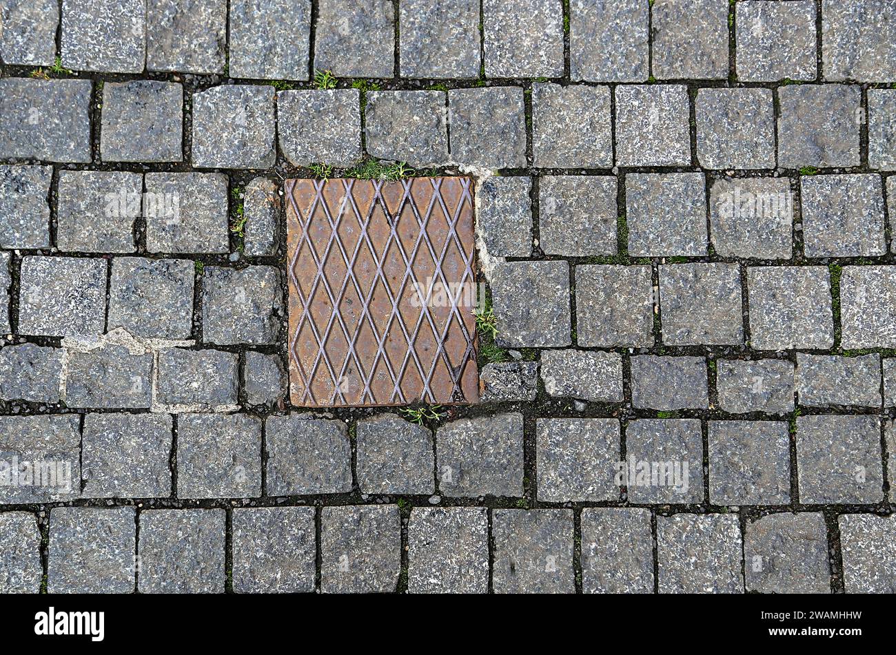 Paving stones background with rusty metal plate Stock Photo - Alamy