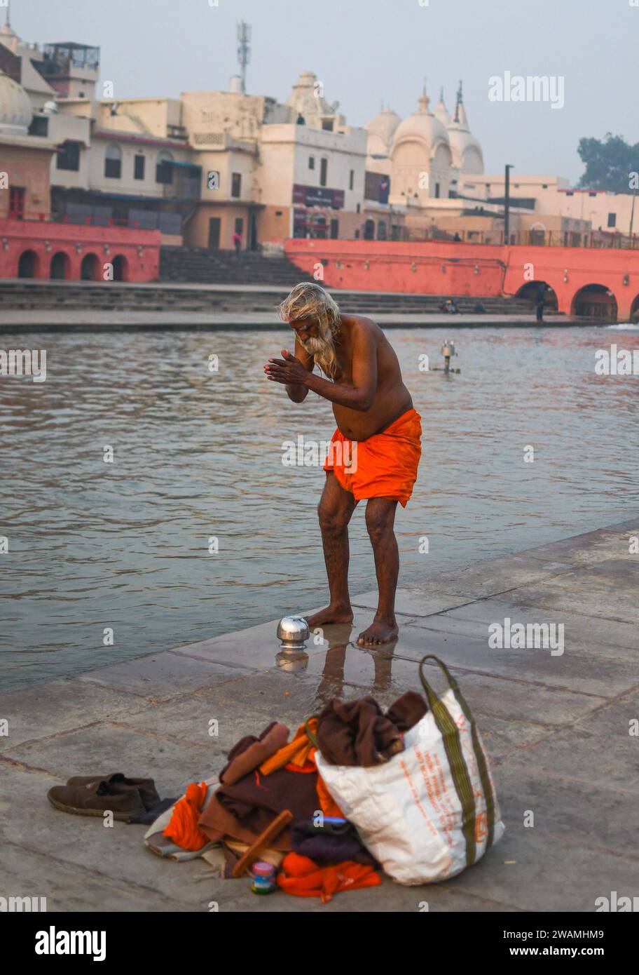 A Hindu devotee offers his prayers on the banks of the Sarayu River ...