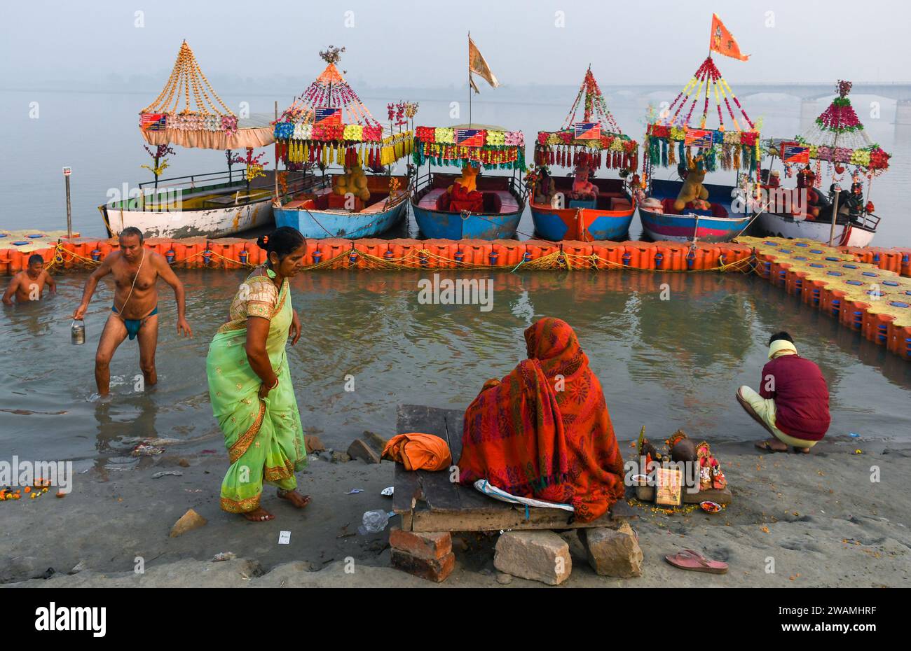 Devotees take bath in the river Sarayu before offering prayers as part ...