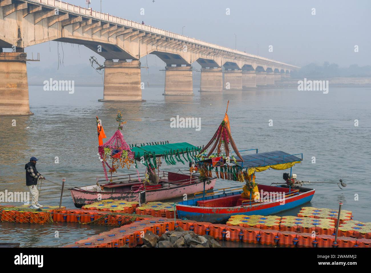Ayodhya, India. 26th Dec, 2023. A man anchors a boat along the banks of ...