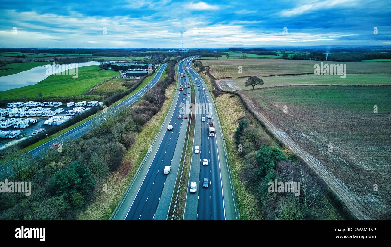 Aerial view of a busy highway with cars, surrounded by green fields and ...