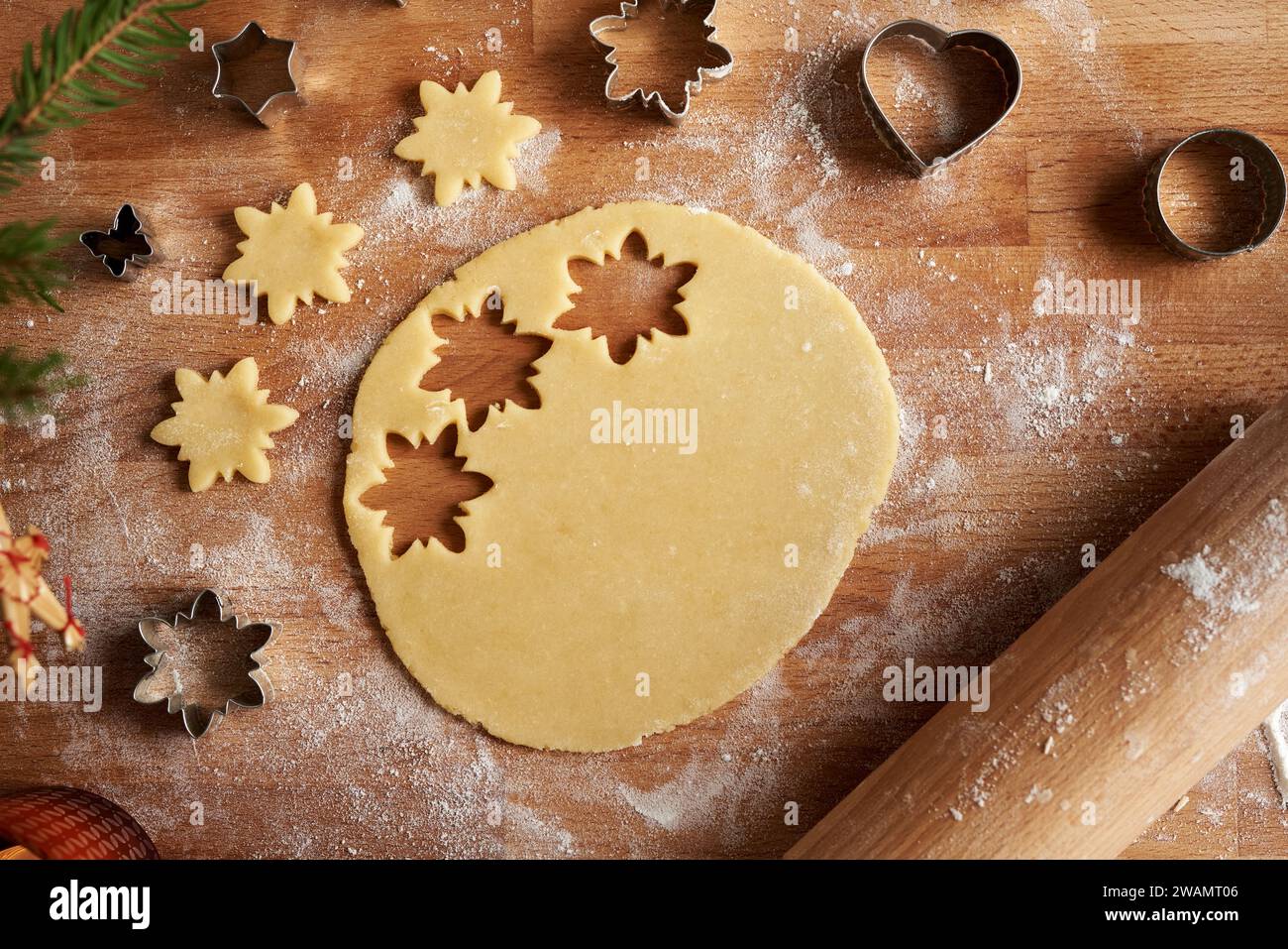 Raw pastry dough from which star shapes are being cut out, top view ...