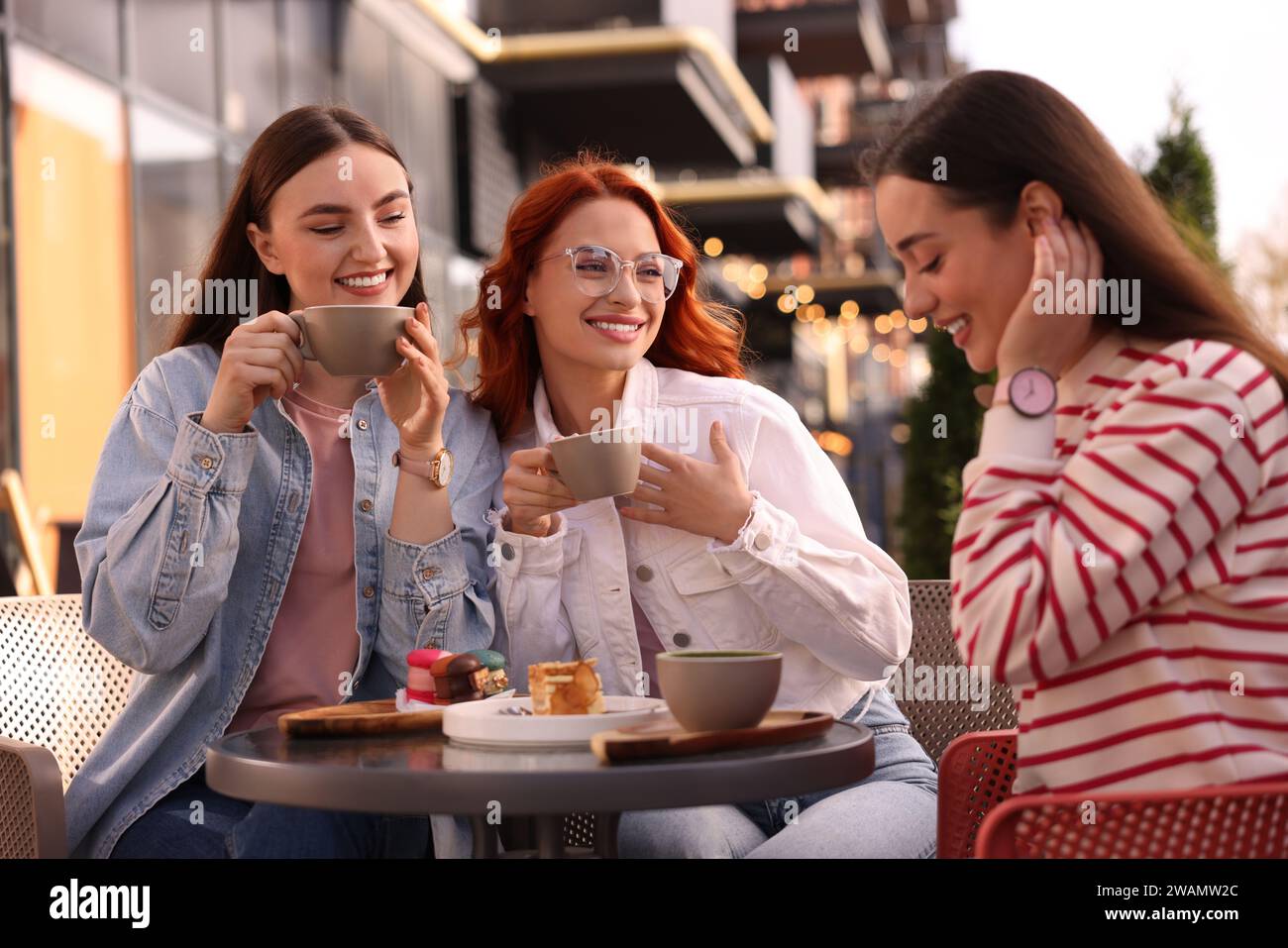 Happy friends drinking coffee in outdoor cafe Stock Photo - Alamy