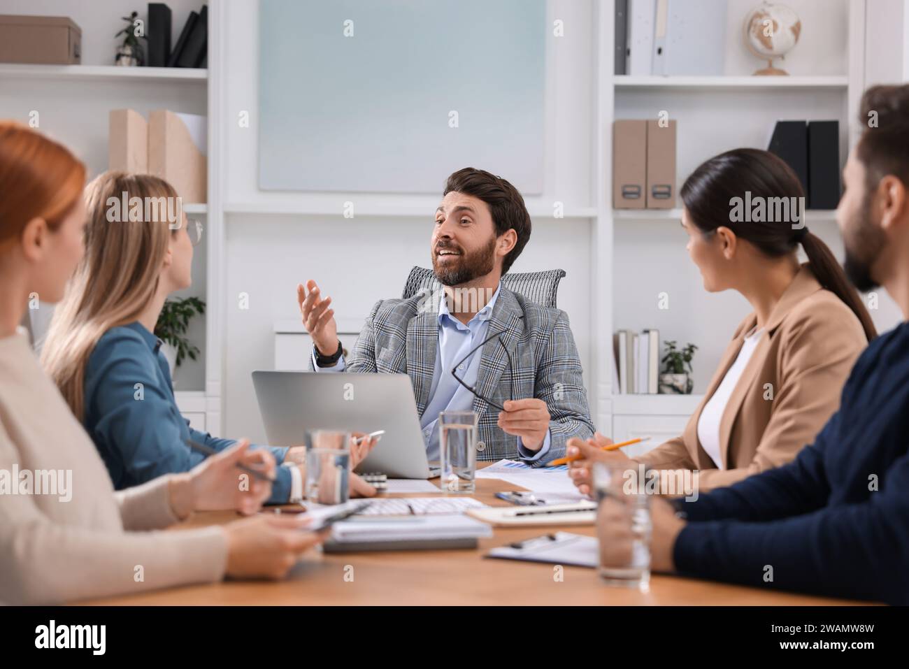 Team of employees working together in office Stock Photo - Alamy