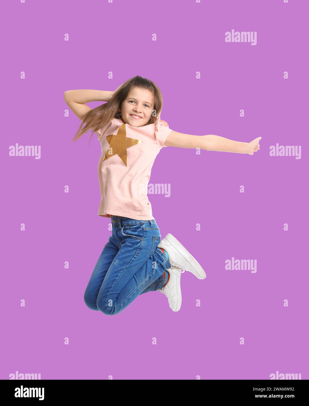 Happy cute girl jumping on violet background Stock Photo - Alamy