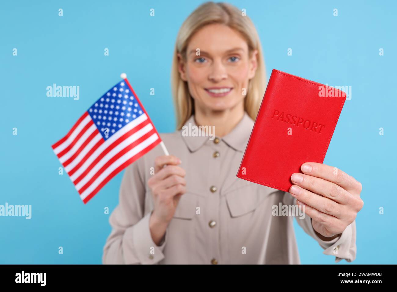 Immigration. Happy woman with passport and American flag on light blue ...