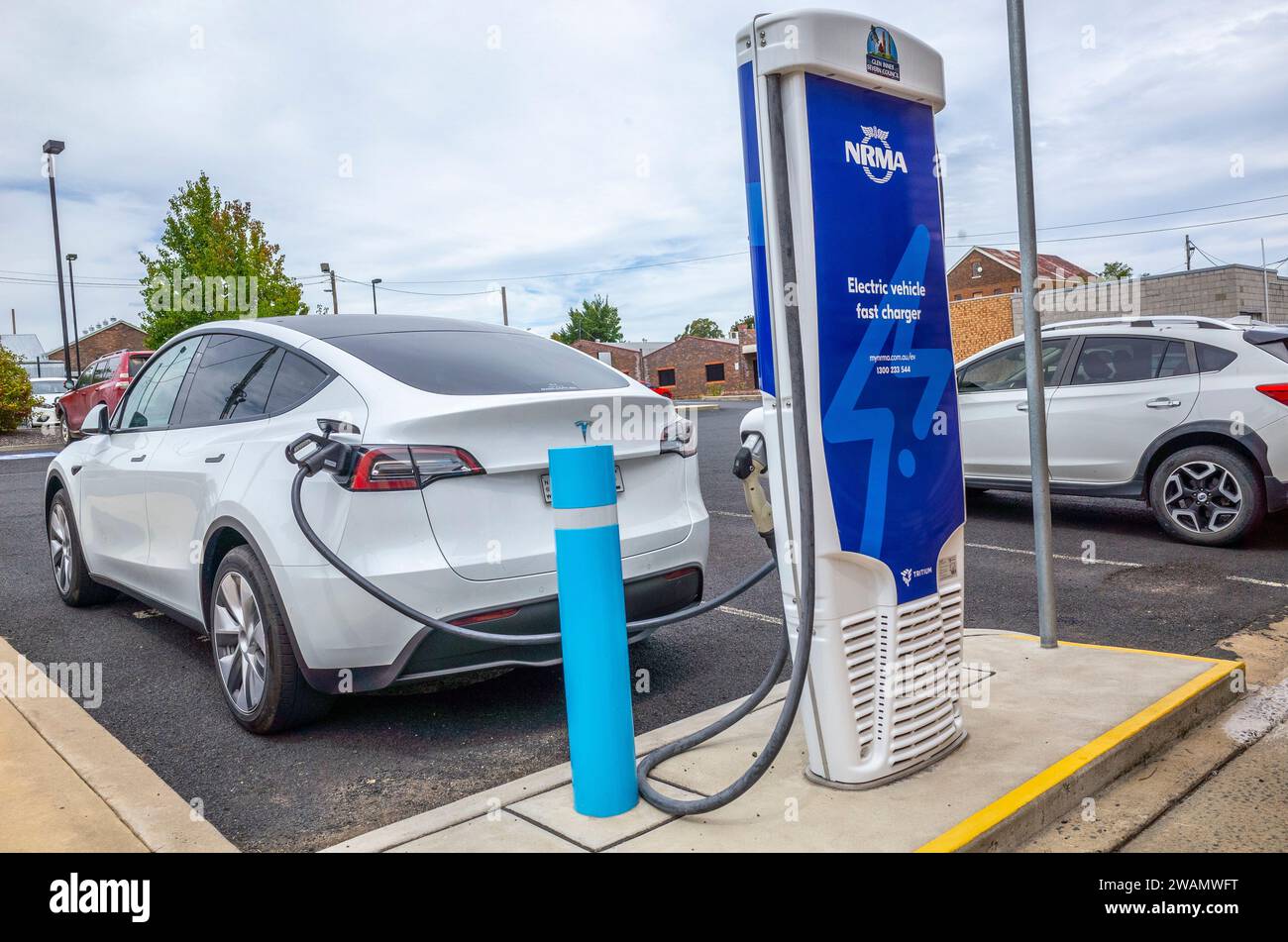 Tesla electric vehicle being recharged at the NRMA EV Charger behind ...