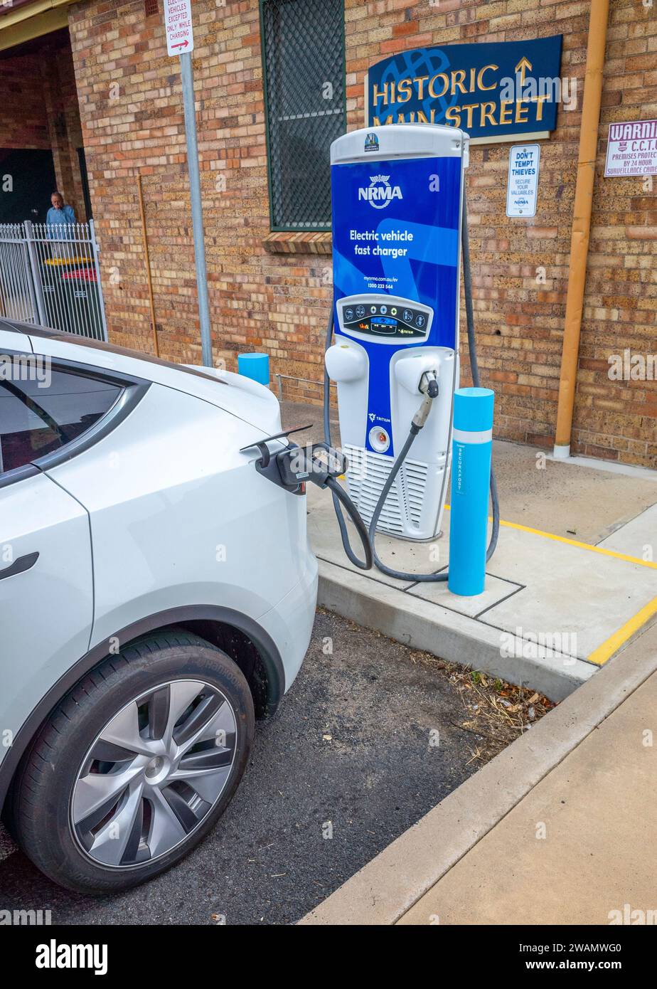 Tesla electric vehicle being recharged at the NRMA EV Charger behind ...