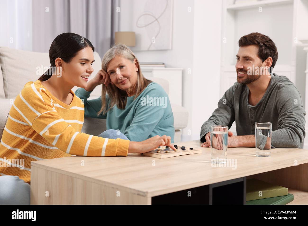 Family playing checkers at coffee table in room Stock Photo - Alamy