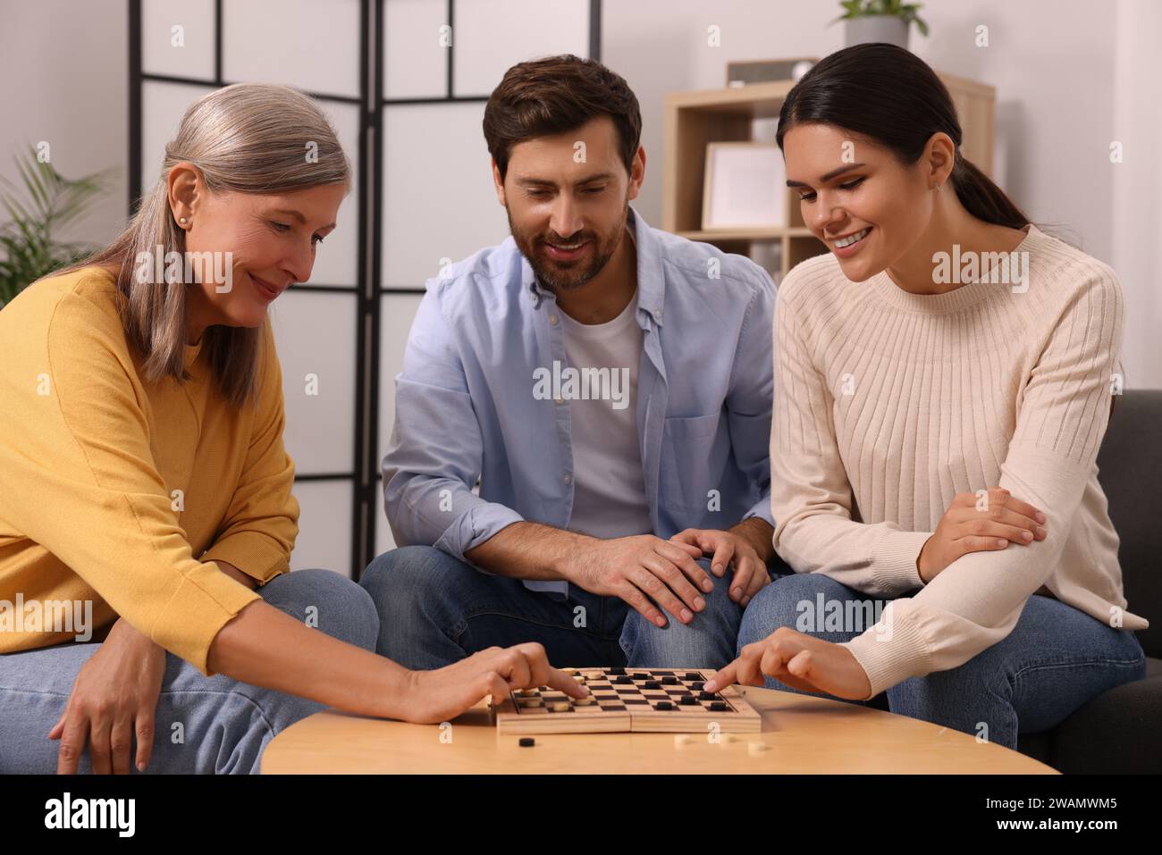 Family playing checkers at coffee table in room Stock Photo - Alamy