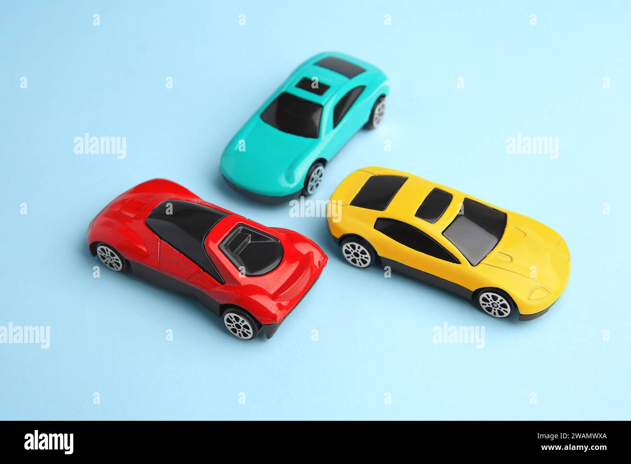 Different bright cars on light blue background. Children`s toys Stock ...