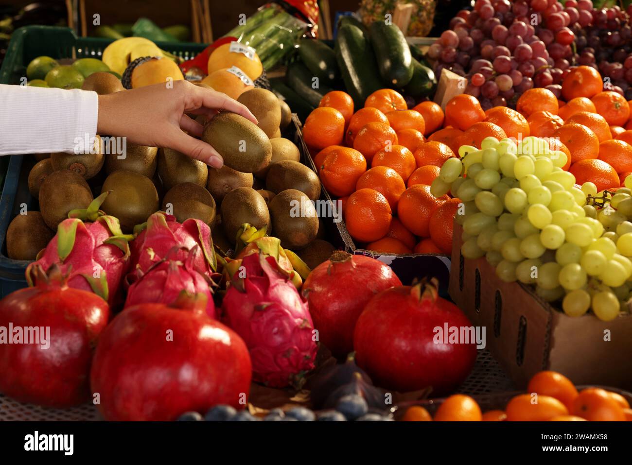 Woman picking fresh kiwi at market, closeup Stock Photo - Alamy
