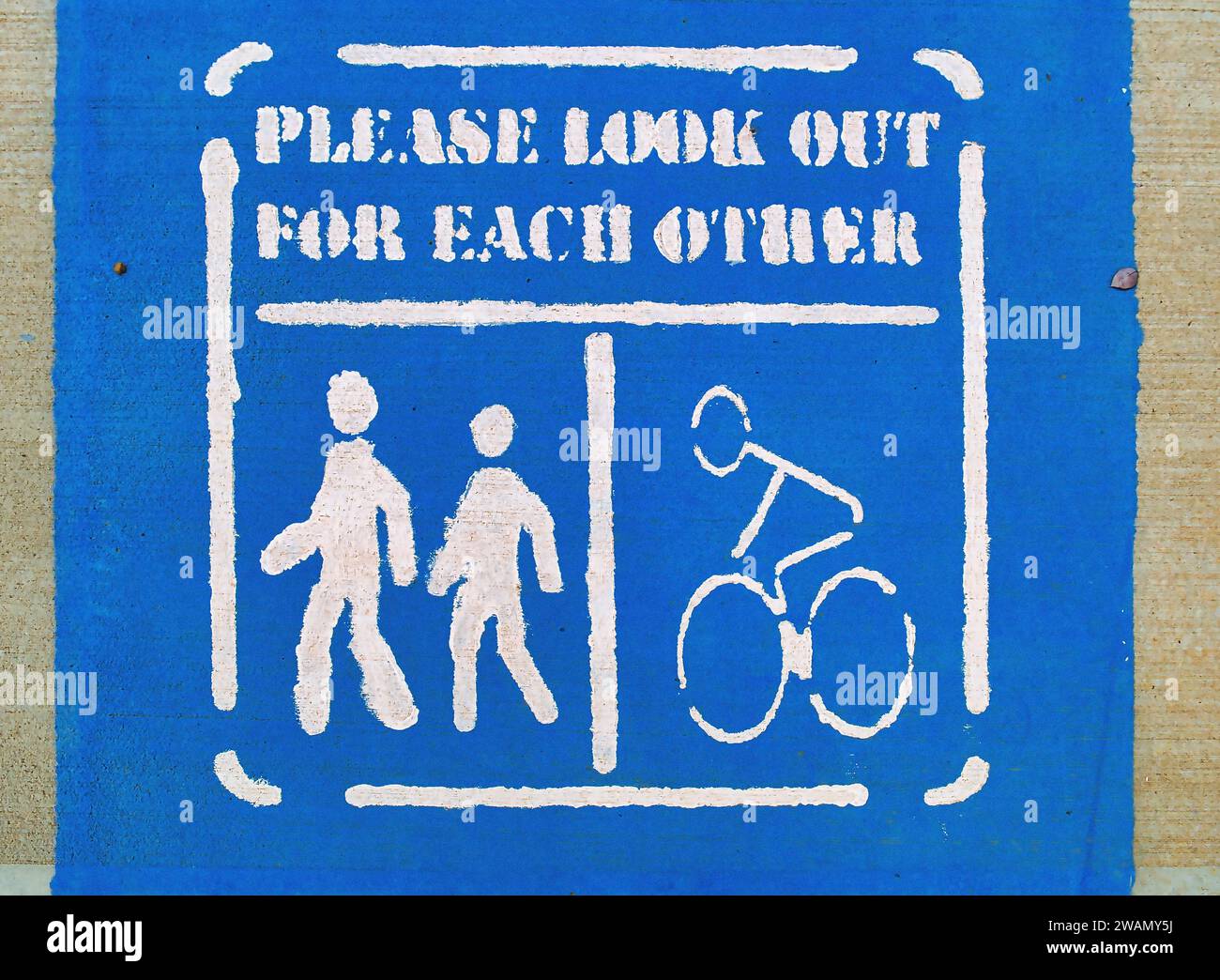 Painted sign on a shared bicycle path and footpath urging users to look ...
