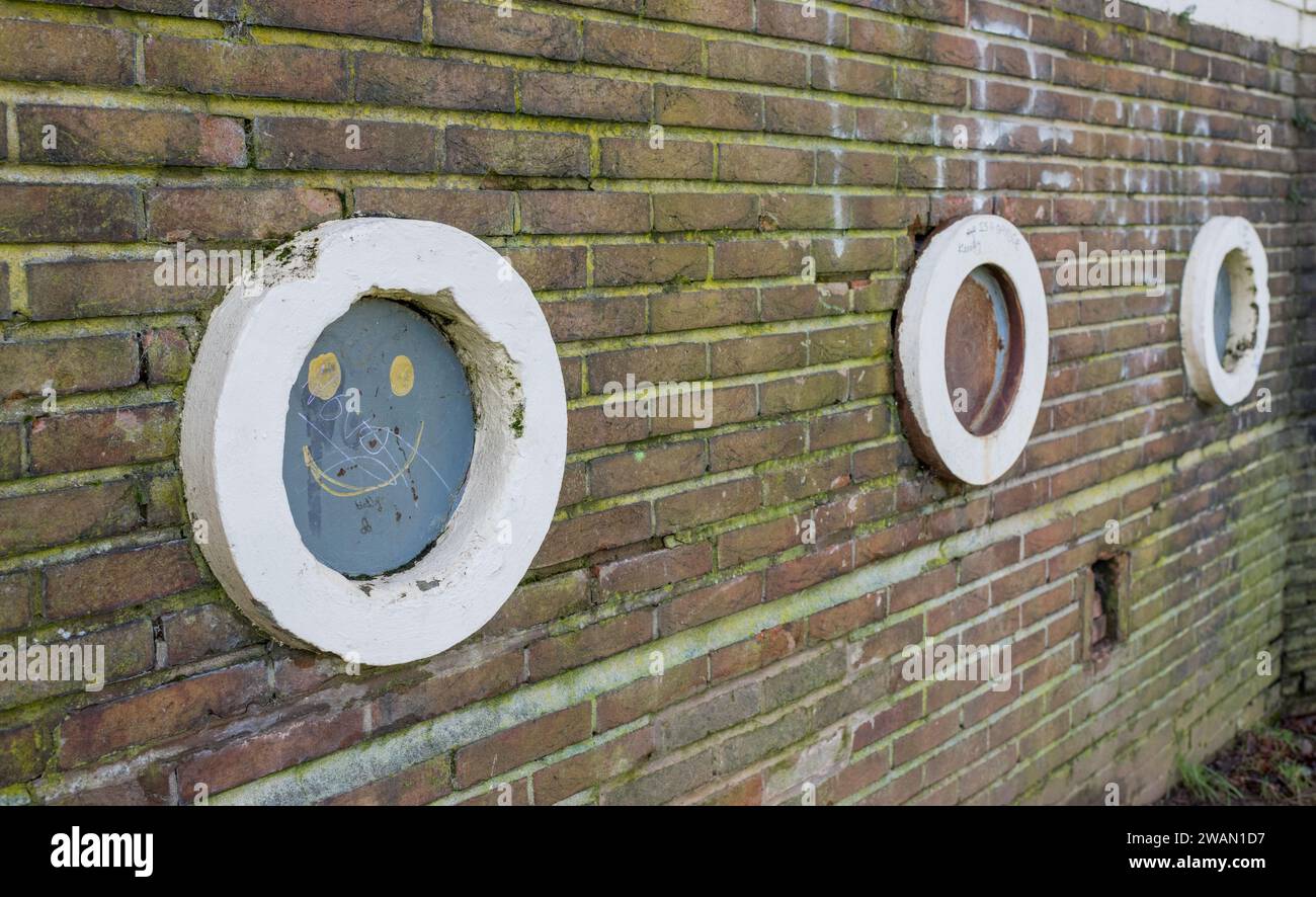 Round concrete windows or port holes mounted into the brick base of the ...