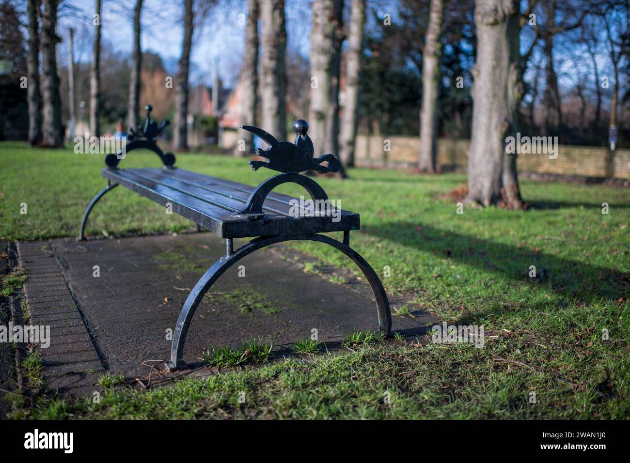 Simple carved metal black bench seat at a local village park Stock ...