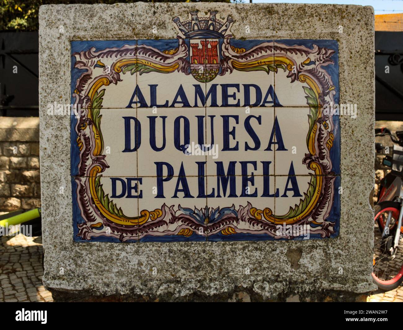 Street sign, made of decorated tiles and blue letters, indicating ...