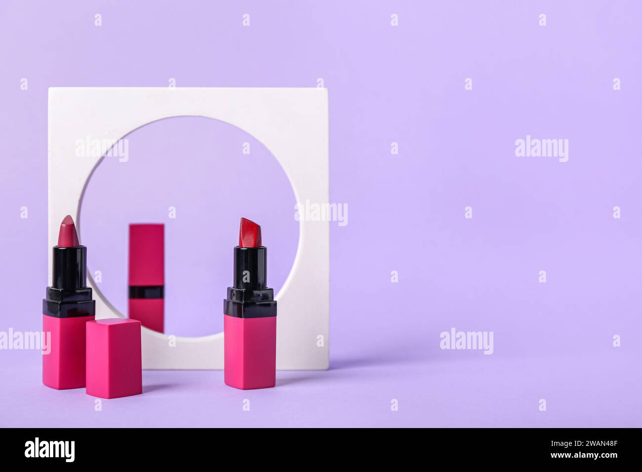 Decorative plaster figure and lipsticks on lilac background Stock Photo ...