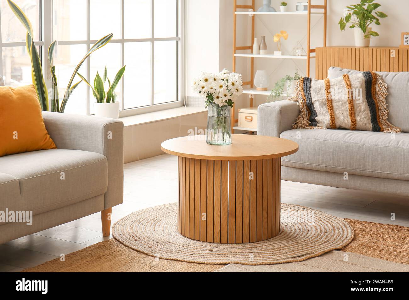 Interior of light living room with grey sofas and wooden coffee table ...