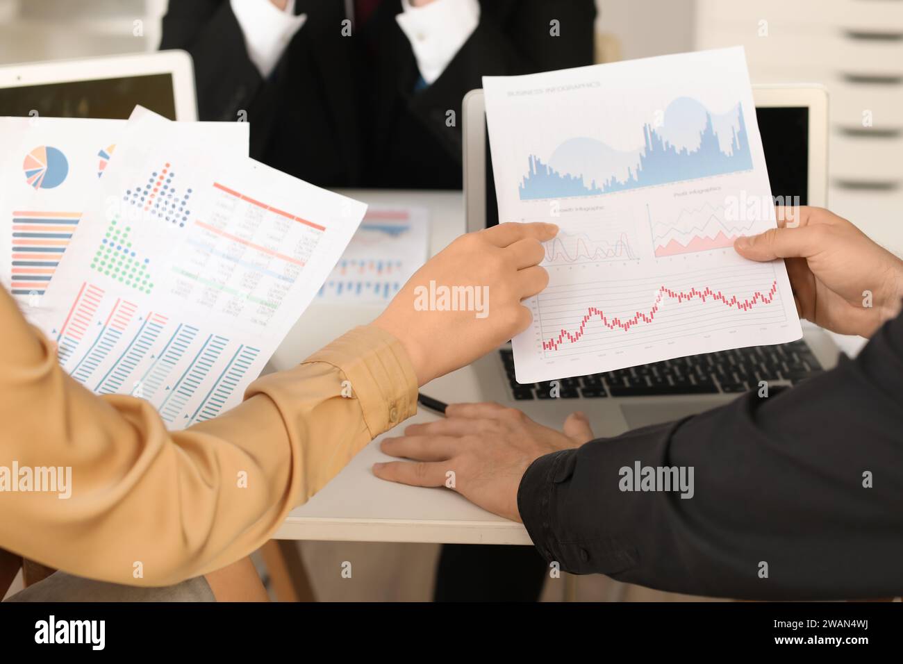 Business consultants working with diagrams at table in office, closeup ...