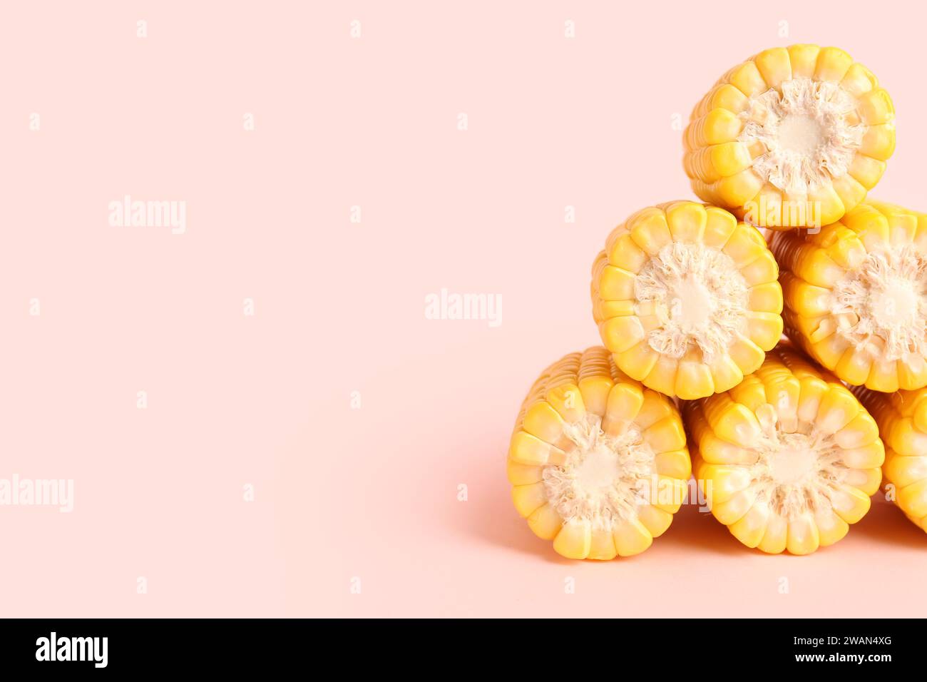 Cut fresh corn cobs on pink background Stock Photo - Alamy