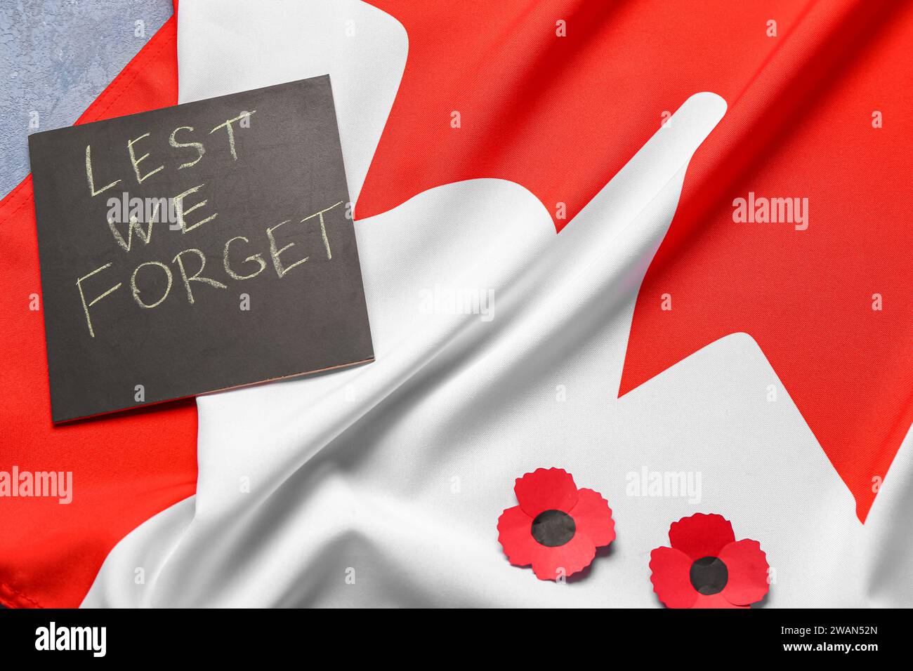 Poppy flowers with flag of Canada and card on grunge blue background ...